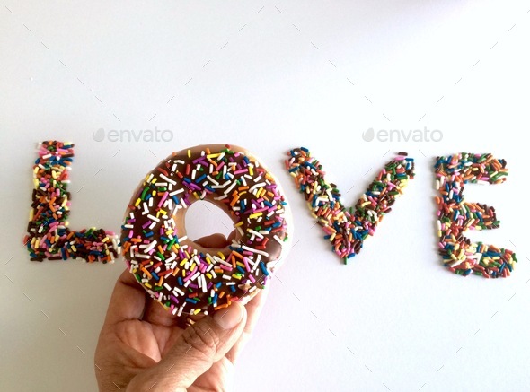 Donuts love. Festive chocolate donut is the “O” of the word love ...