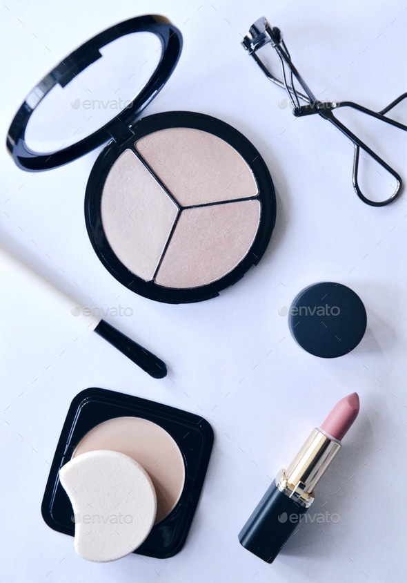 Overhead photo of flat lay makeup essentials and tools on a white ...