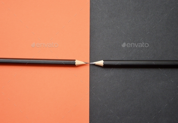 Overhead photo of two pens pointing towards each other on differently ...