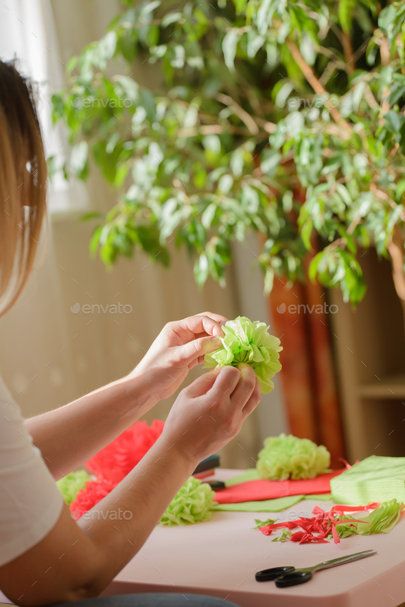 Female hands separating the petals of a green paper flower from napkins ...