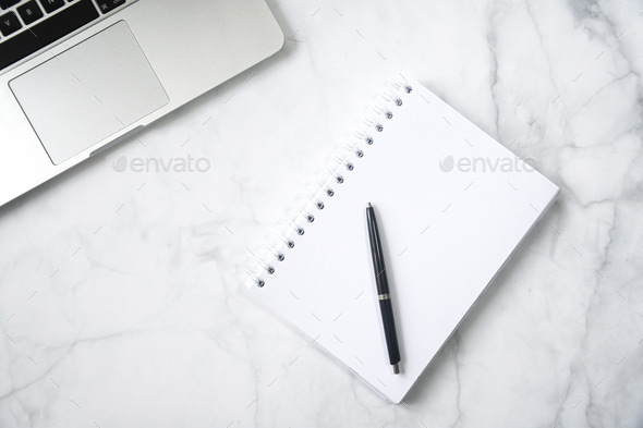 Overhead of white or bright working space or desktop with laptop and ...