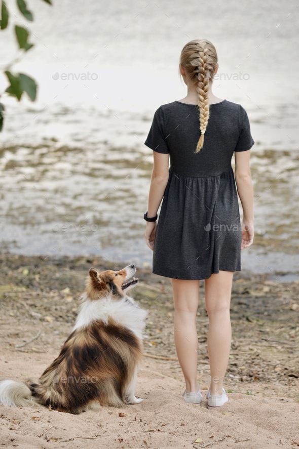 Portrait from behind of a young millennial woman girl with braided hair ...