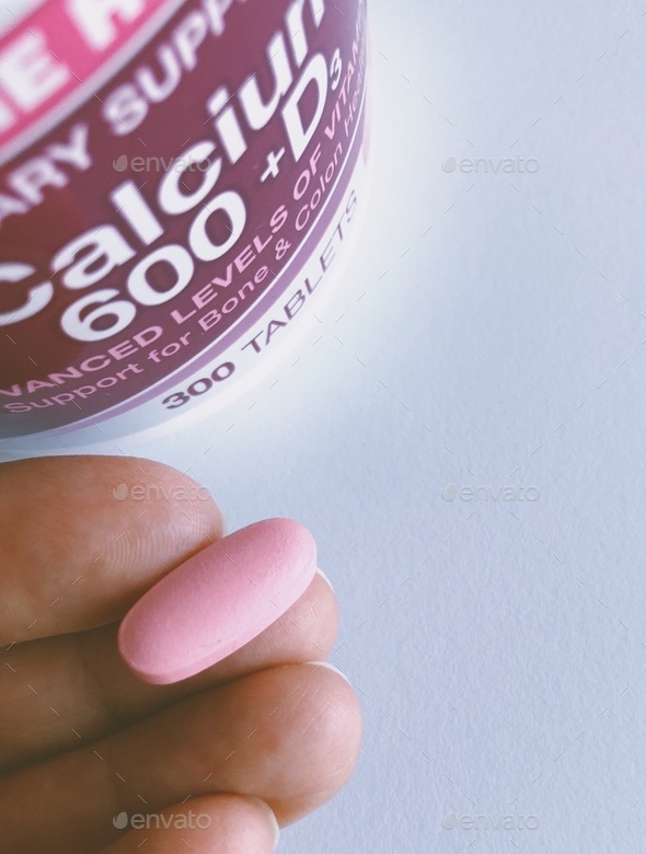 Woman taking calcium-vitamin D supplement for bone health heart muscles ...