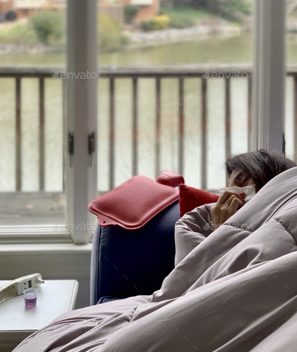 Sick woman with chills & congestion taking medicine & getting some rest ...