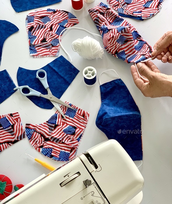 Overhead workspace of woman making face masks using USA patriotic ...