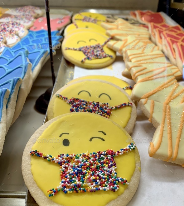 Yellow winking emoji cookies faces with colorful sprinkles face masks ...