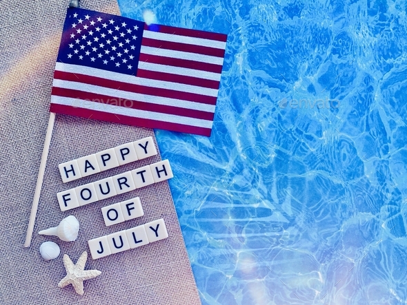 Flat lay with Happy Fourth of July written with tiles with USA flag sea ...