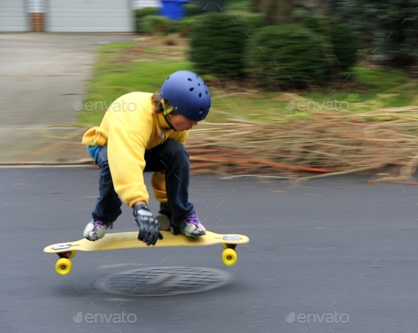 Extreme sport. Teen wearing yellow top skateboarding/longboarding ...