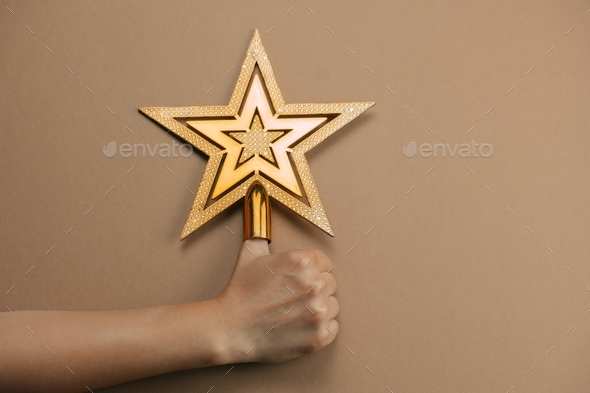 hand with super gesture decorated with golden star Stock Photo by aleeenot