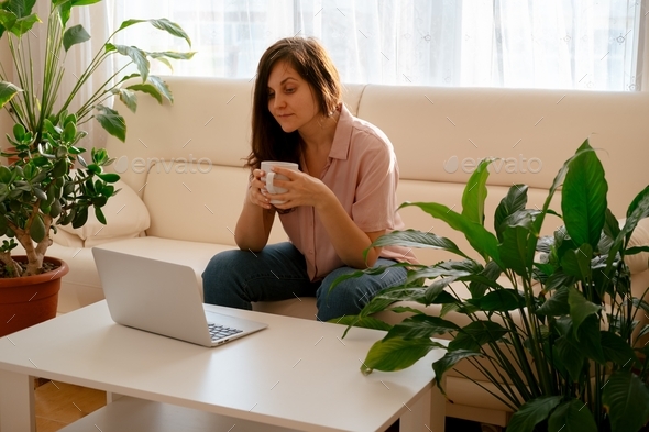 Young woman watching on a computer screen. Modern workplace and remote ...