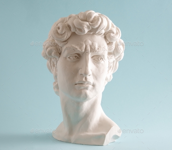 White plaster statue head of David on pastel blue background. Minimal ...