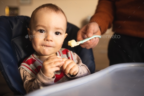 Little boy is learning to eat. Complementary feeding of the child. The ...