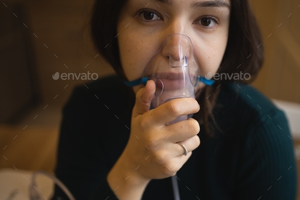 The girl is inhaled at home.Inhaler. Inhalation. Treatment at home ...