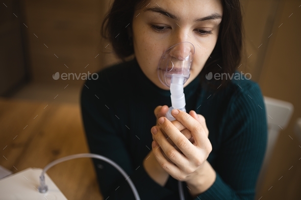 The girl is inhaled at home.Inhaler. Inhalation. Treatment at home ...