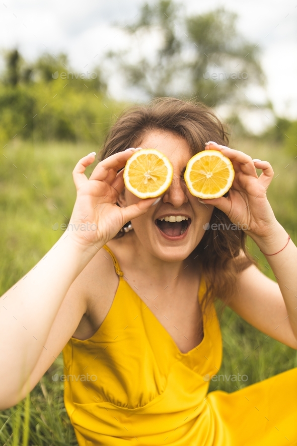 Beautiful girl with lemons in her hands. Positive girl playing with ...