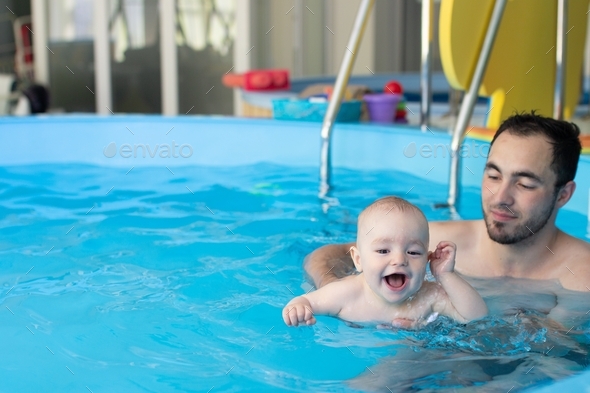 A little boy bathes in a children's pool. Swimming lessons for babies ...