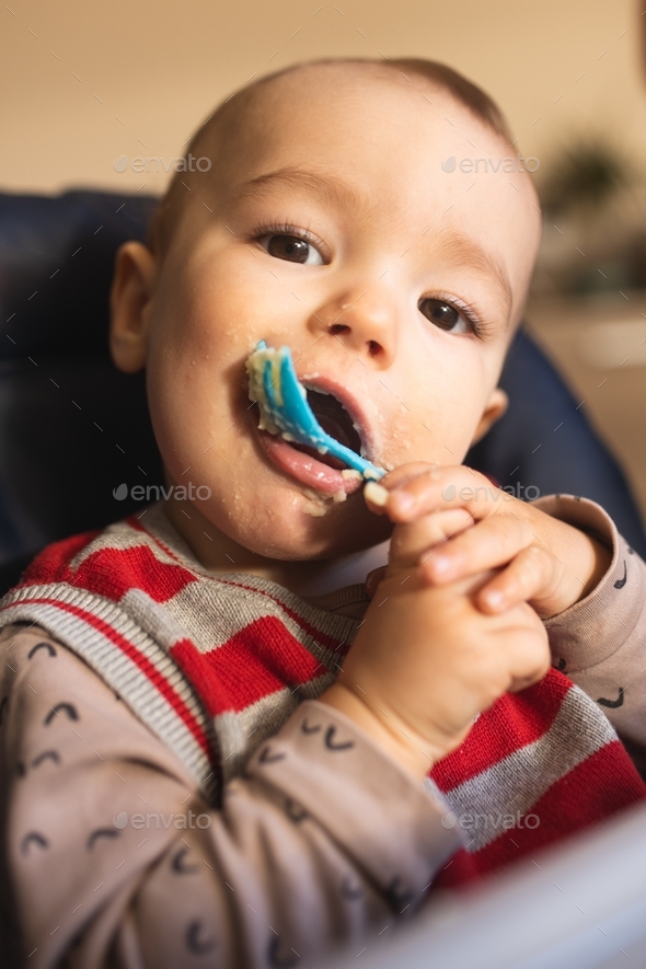 Little boy is learning to eat. Complementary feeding of the child. The ...