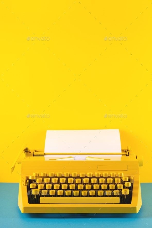 Yellow bright typewriter on a yellow and blue. Symbol for writing, new ...