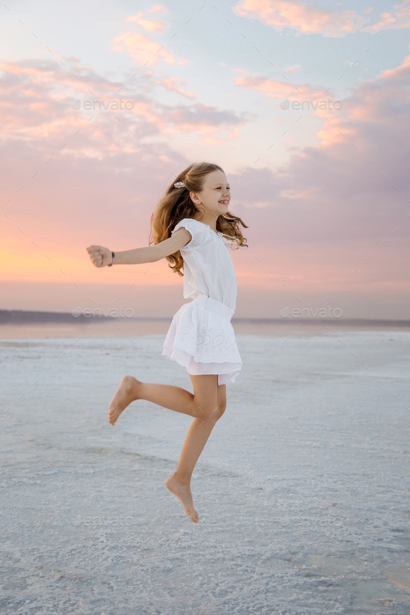 girl jumping very high on a gentle pink sunset background Stock Photo ...