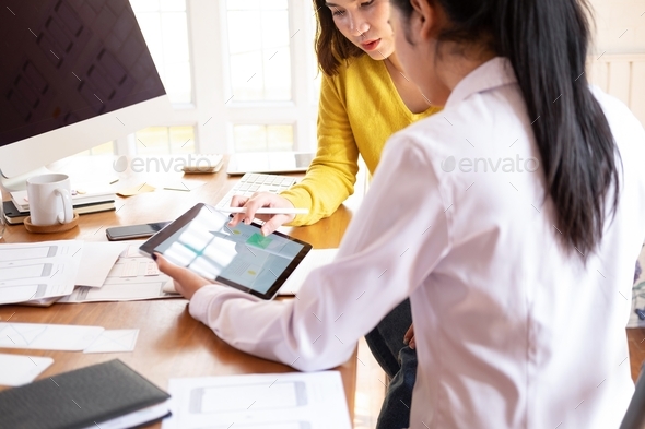 A manager and an employee work together in the office Stock Photo by ijeab