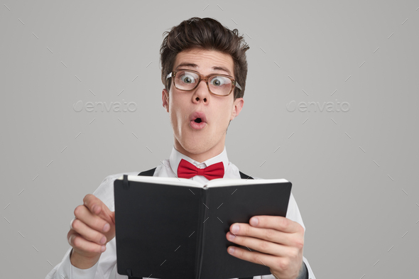 Smart geek in glasses reading book Stock Photo by kegfire | PhotoDune