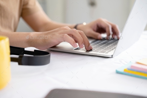 Close up hand using computer laptop for typing and working online ...