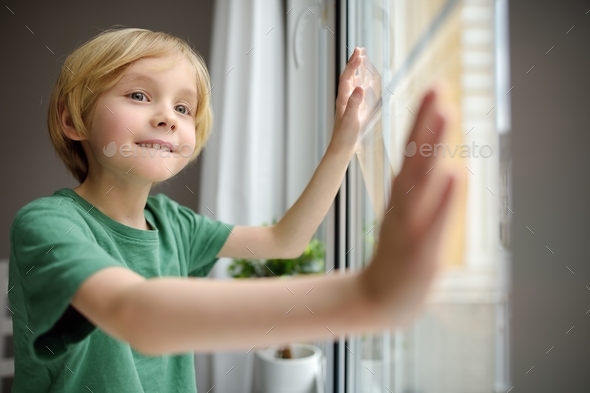 Portrait of little boy standing in front of window at home. Cute child ...