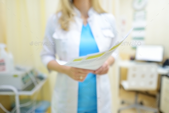 The surgeon doctor is examining a results of check up of patient and ...