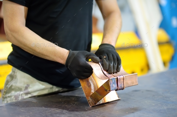 Metalwork craftsman making handmade lamp at workshop. Man worker is ...