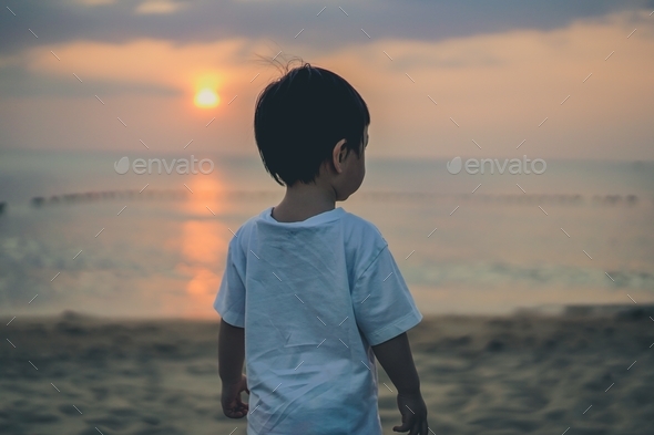 View form behind of Little boy standstill looking to the sea view ...