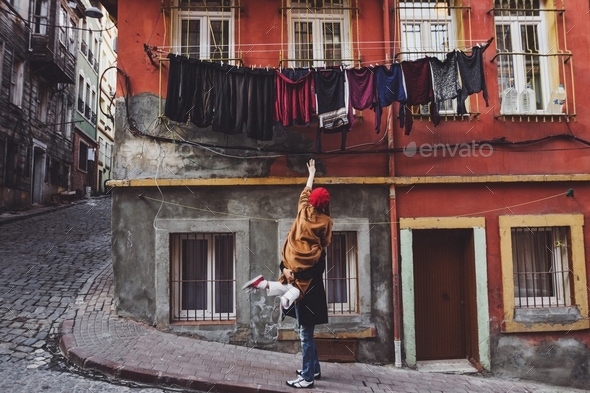 Young couple having fun in drying laundry hanging at old streets of ...