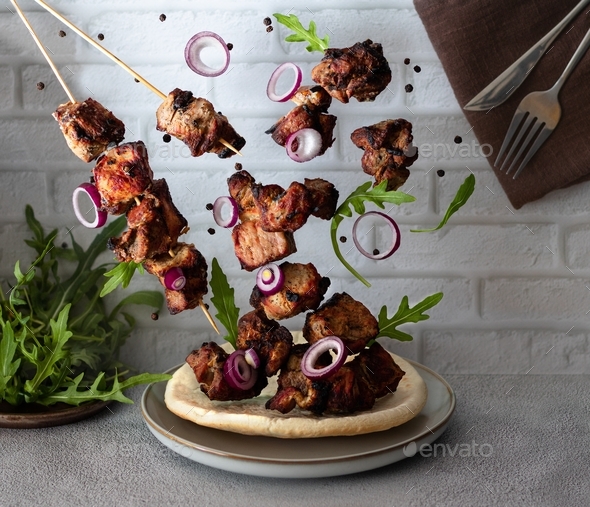 Abstraction, meat skewers, flying pieces of fried meat. Barbecue meat ...
