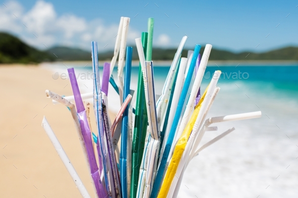 Heap of used plastic straws on background of clean tropical beach and ...