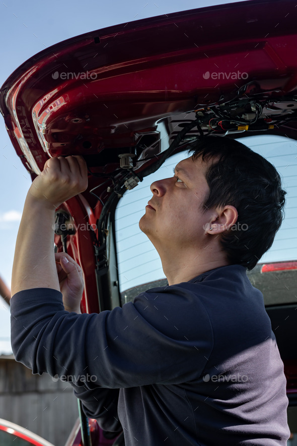 Repair work. Mechanic. Car headlight replacement. Close-up. Trunk ...