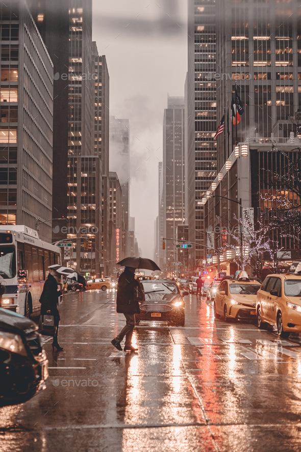 Raining evening in New York. Crossing the street. Man with umbrella ...