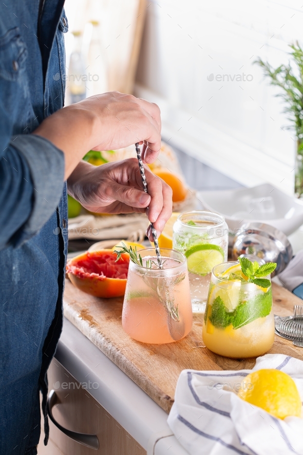 Mixologist making refreshing cocktails with hard seltzer at home Stock Photo by antoninavlasova