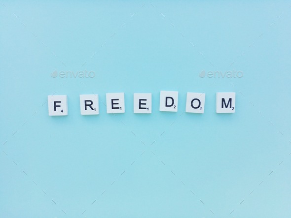 Freedom scrabble letters word on a blue background Stock Photo by ...