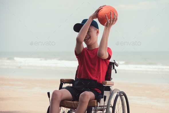 Ball in hands of happy disabled teenage boy, Activity outdoors with ...