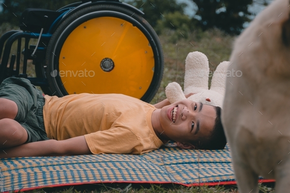 Disabled child smile face on the mat holding teddy bear and wheelchair ...