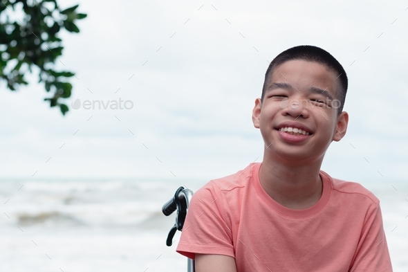 Disabled child on wheelchair with smiling happy face on sea beach ...