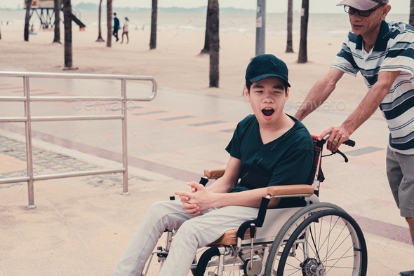 Disabled teenager boy on wheelchair and carer in public places. Stock ...