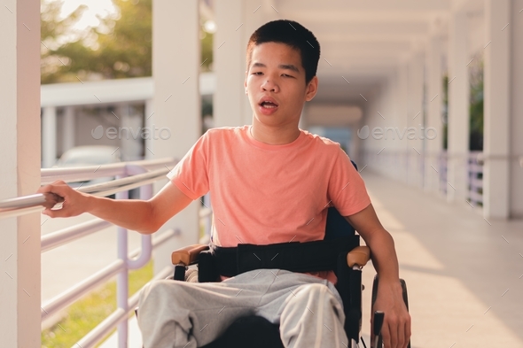 Confident handicapped teenager boy on wheelchair with happy face on ...