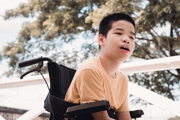 Cute disabled child on wheelchair on nature background. Stock Photo by ...