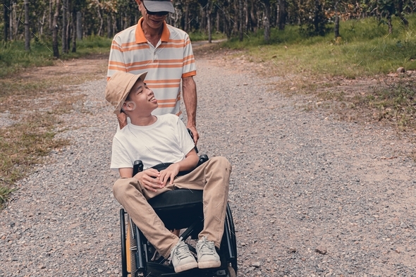 Happy handicapped teenager boy smiling face and parent with outdoors ...