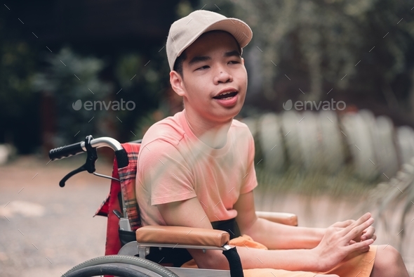 Asian teenager boy with disabilities on wheelchair happy face in nature ...
