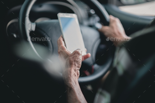 Man's hand holding a phone while driving, using phone for looking map ...