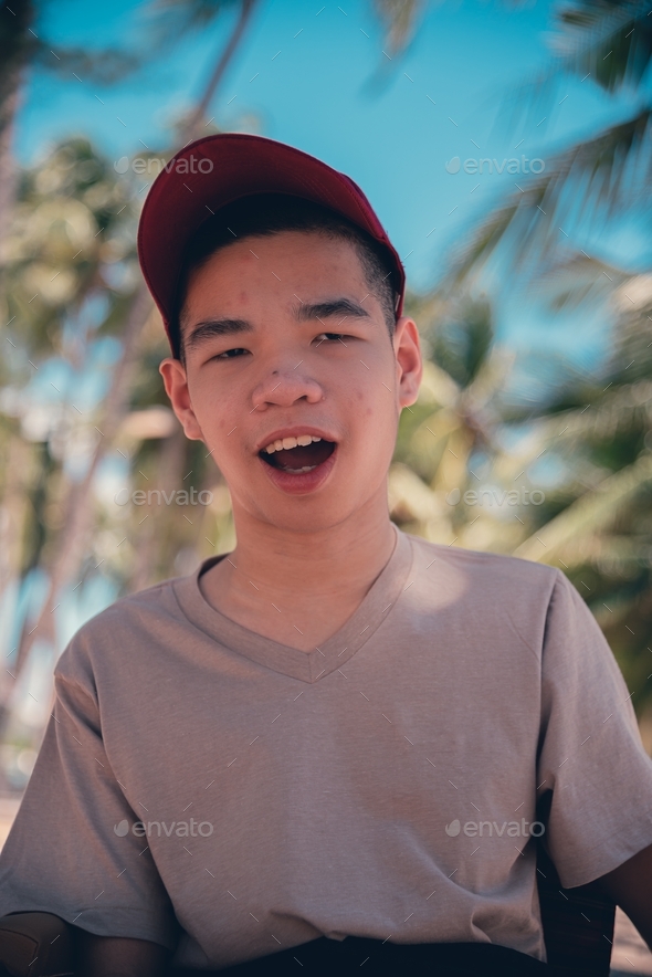 Happy handicapped teenager boy in wheelchair wearing red cap and ...