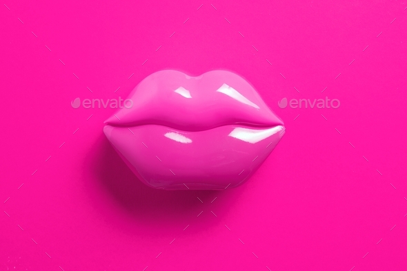 Artificial pink lips shape on pink background. Beauty, care, perfection ...