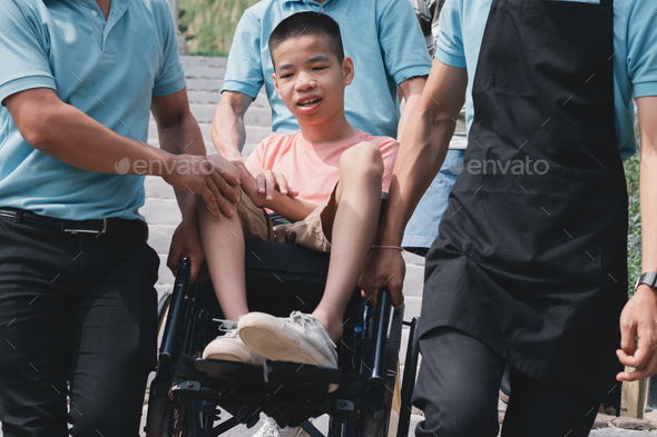 Disabled child smile on wheelchair with service personnel help lift the ...