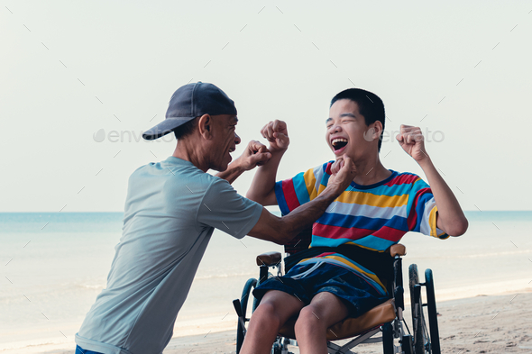 Disabled child on wheelchair fun with activities at the sea beach ...